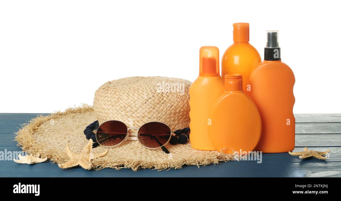 Sun protection products and beach accessories on blue wooden table ...