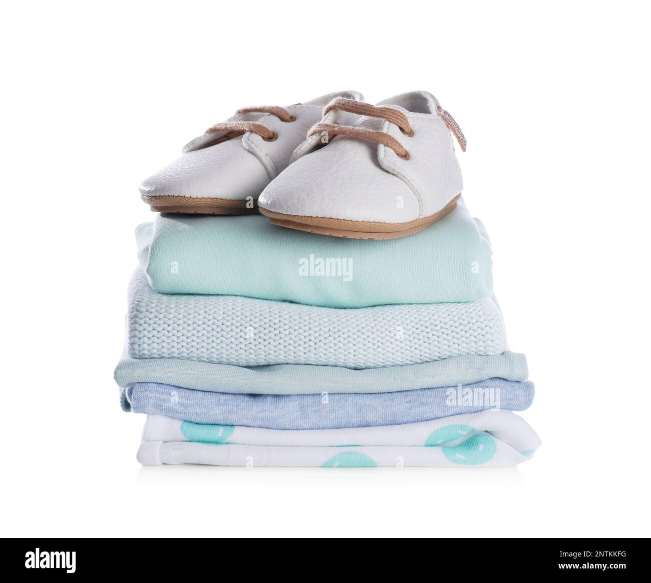 Stack of clean baby's clothes and small shoes on white background Stock ...
