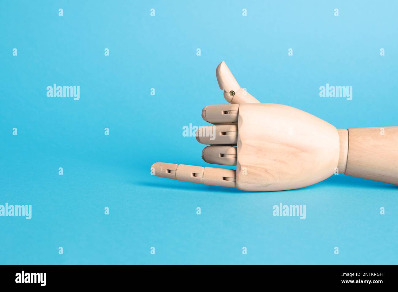 Wooden mannequin hand on light blue background. Space for text Stock ...