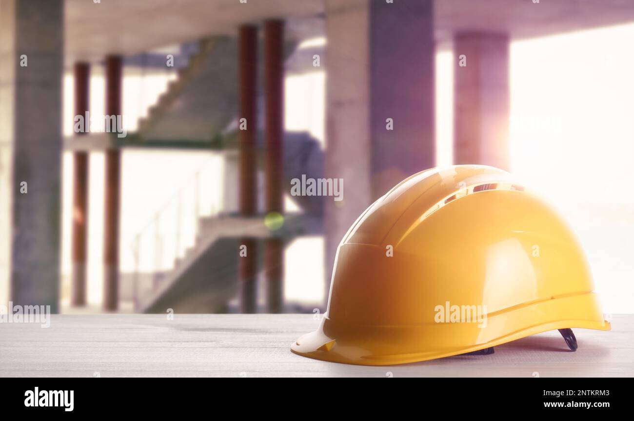 Hard hat on white wooden surface at construction site with unfinished ...
