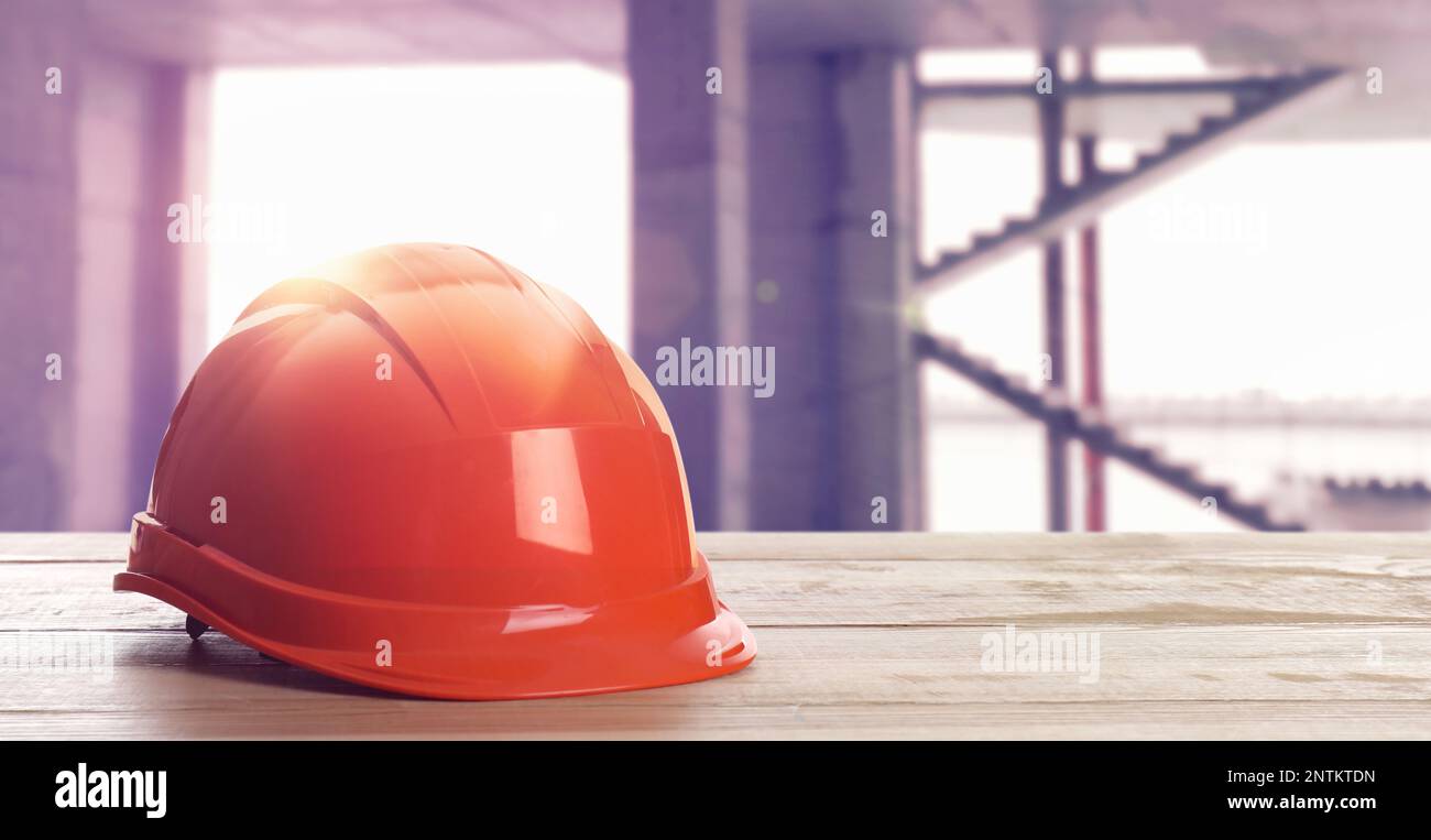 Hard hat on wooden surface at construction site with unfinished ...