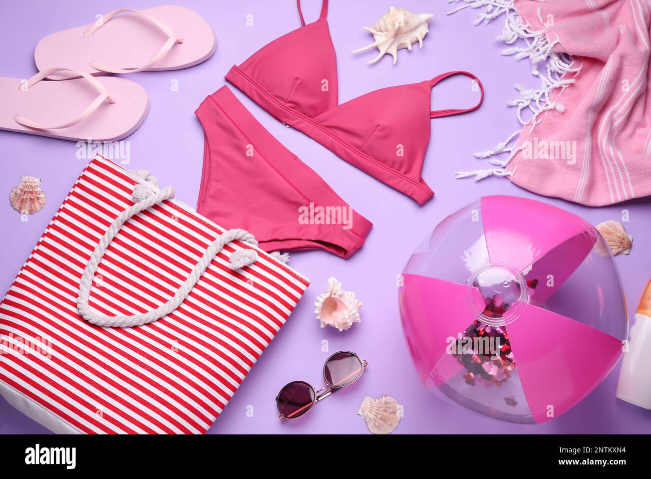 Flat lay composition with beach ball and other accessories on violet ...