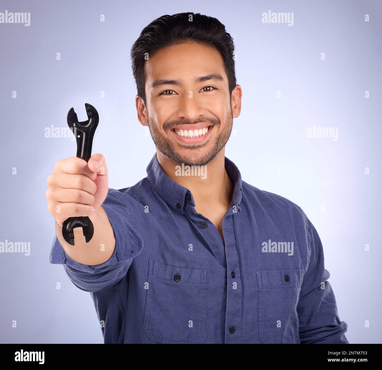 Portrait of man with wrench tool isolated on studio background for ...