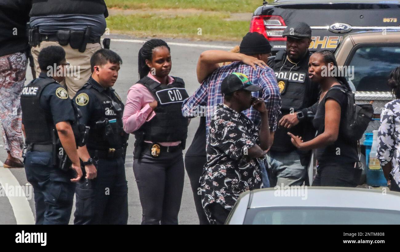 Law enforcement officers console family members near a scene after a ...