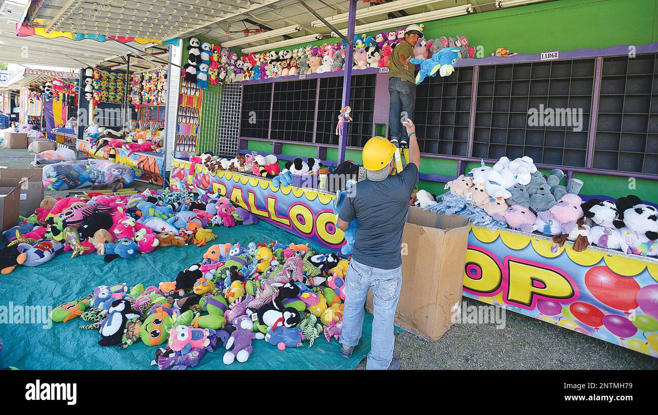 A worker tosses a stuffed animal to another worker while preparng the ...