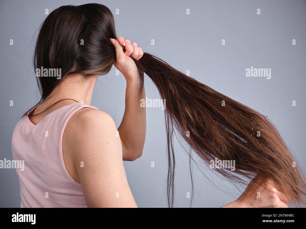 Back View Brunette Young Woman Combing Pulls Wet And Tangled Hair After