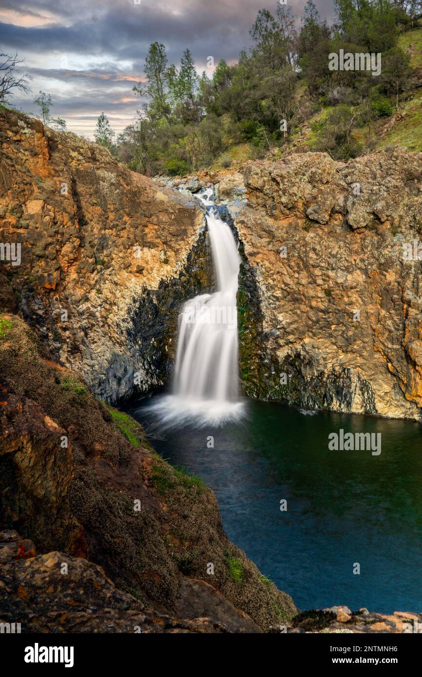A stunning waterfall cascading through a narrow canyon surrounded by ...