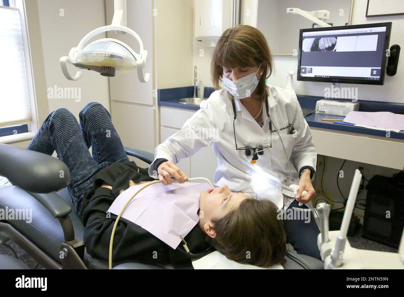 Dr. Jean Creasy works on a tooth extraction on 12 year old Tony ...