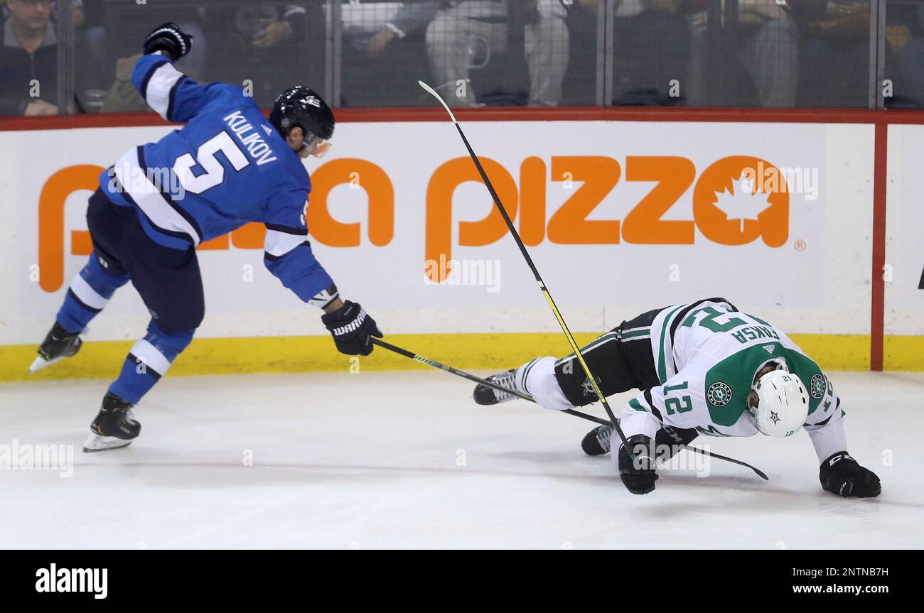 Winnipeg Jets' Dmitry Kulikov (5) has his stick caught between the legs of Dallas Stars' Radek ...