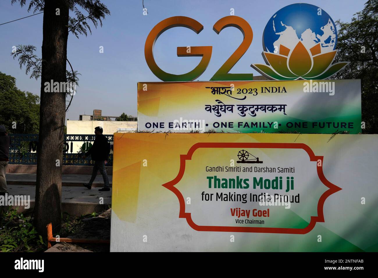 A commuter walks past a G20 logo at a crossing in New Delhi, India ...
