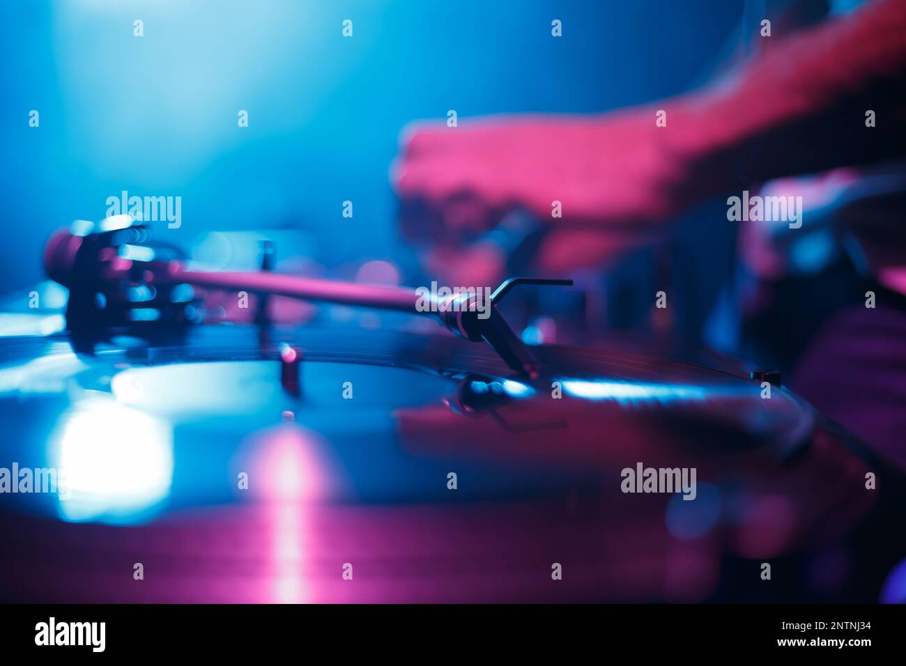 Turntable plays vinyl record with hip hop music on party in night club ...