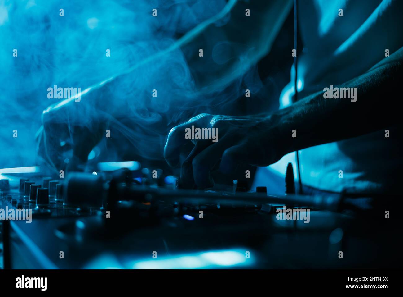 Hip hop dj playing music in smoke on concert. Disc jockey play musical ...