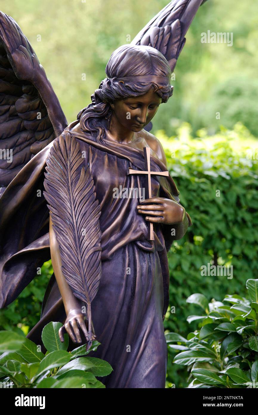 Bronze grave angel with feather and cross Stock Photo - Alamy