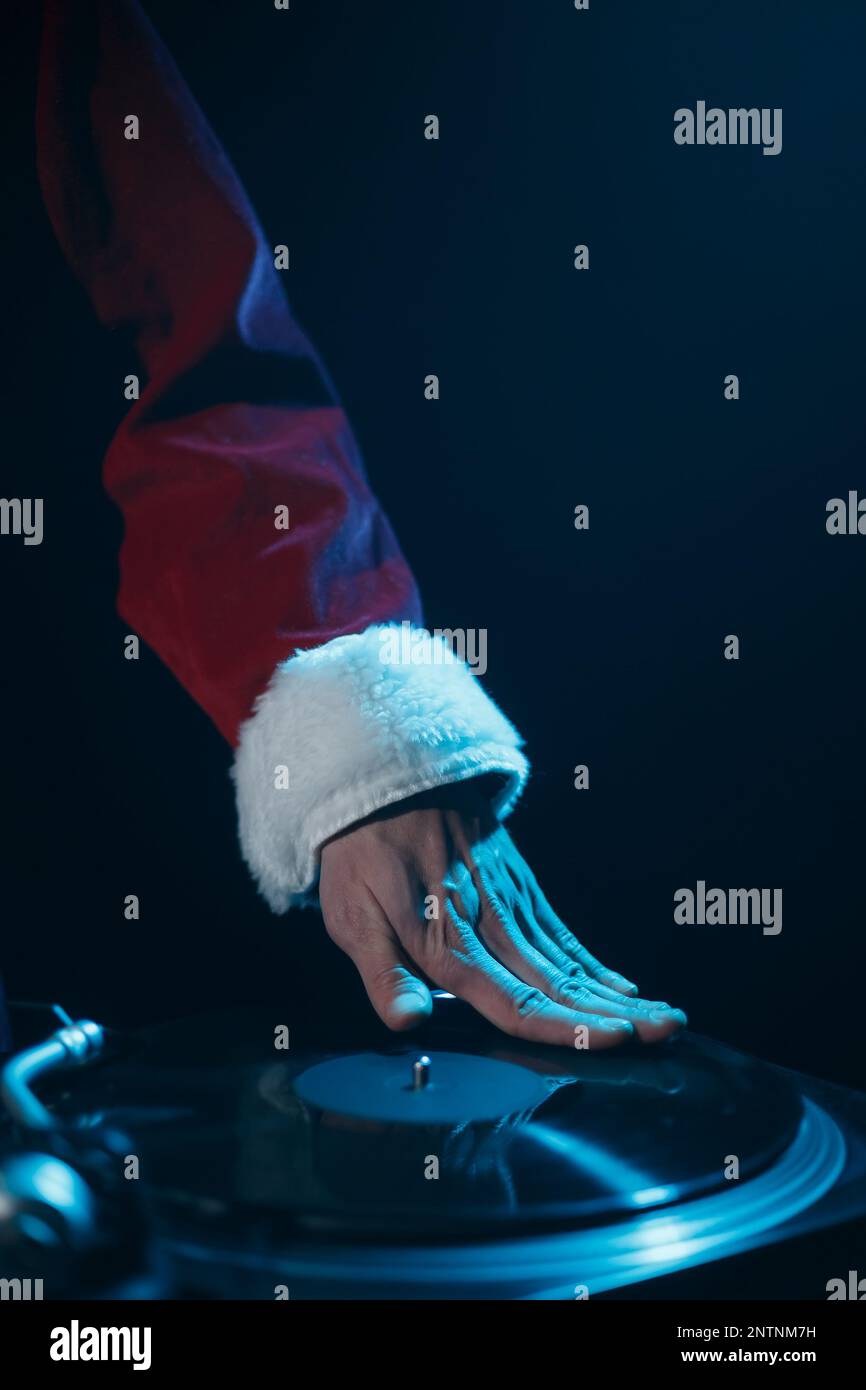 Dj in Santa Claus costume scratches vinyl record on turntable. Disc ...