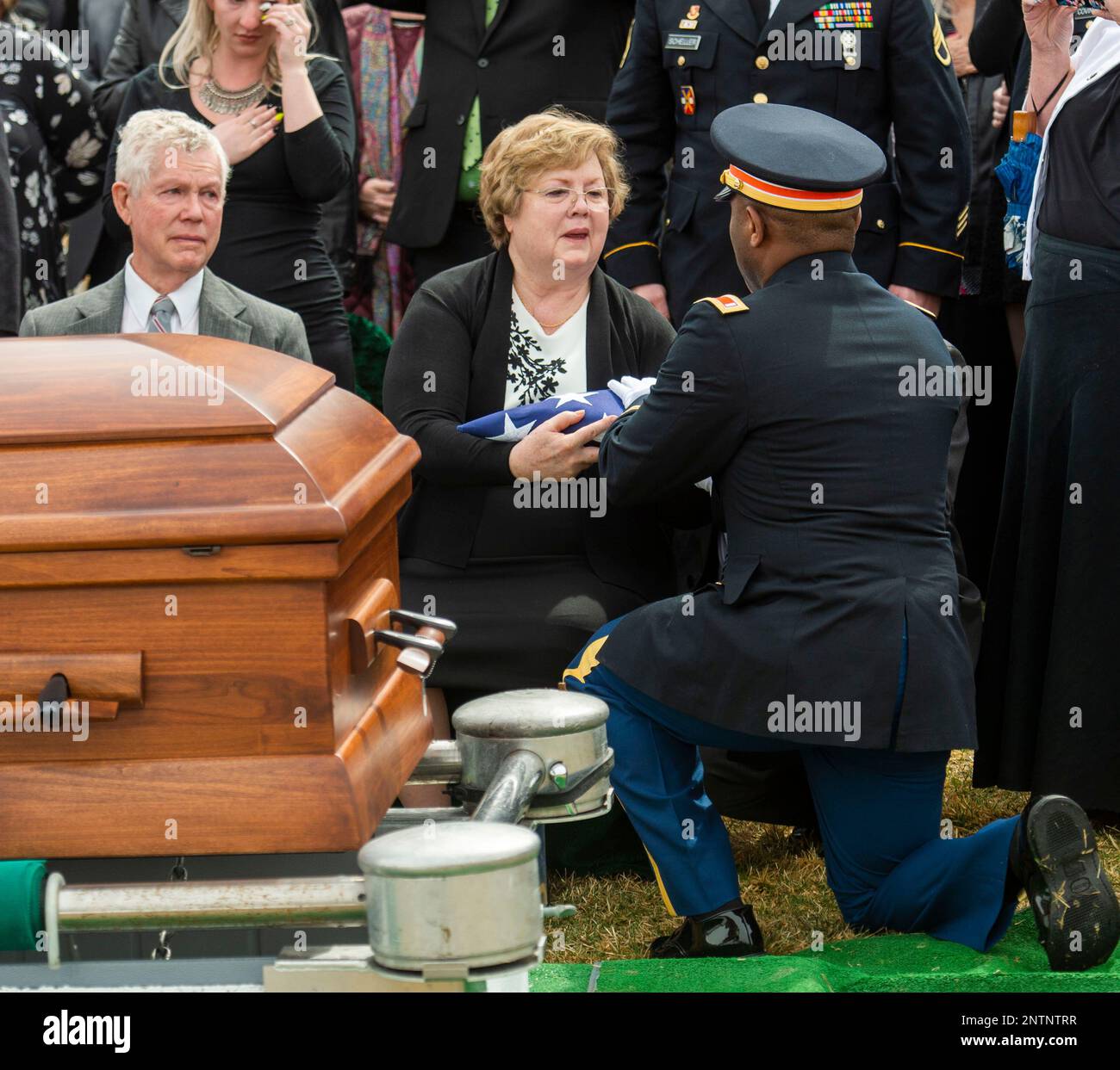 A member of the Honor Guard presents Mary Ann Turner, the daughter of ...