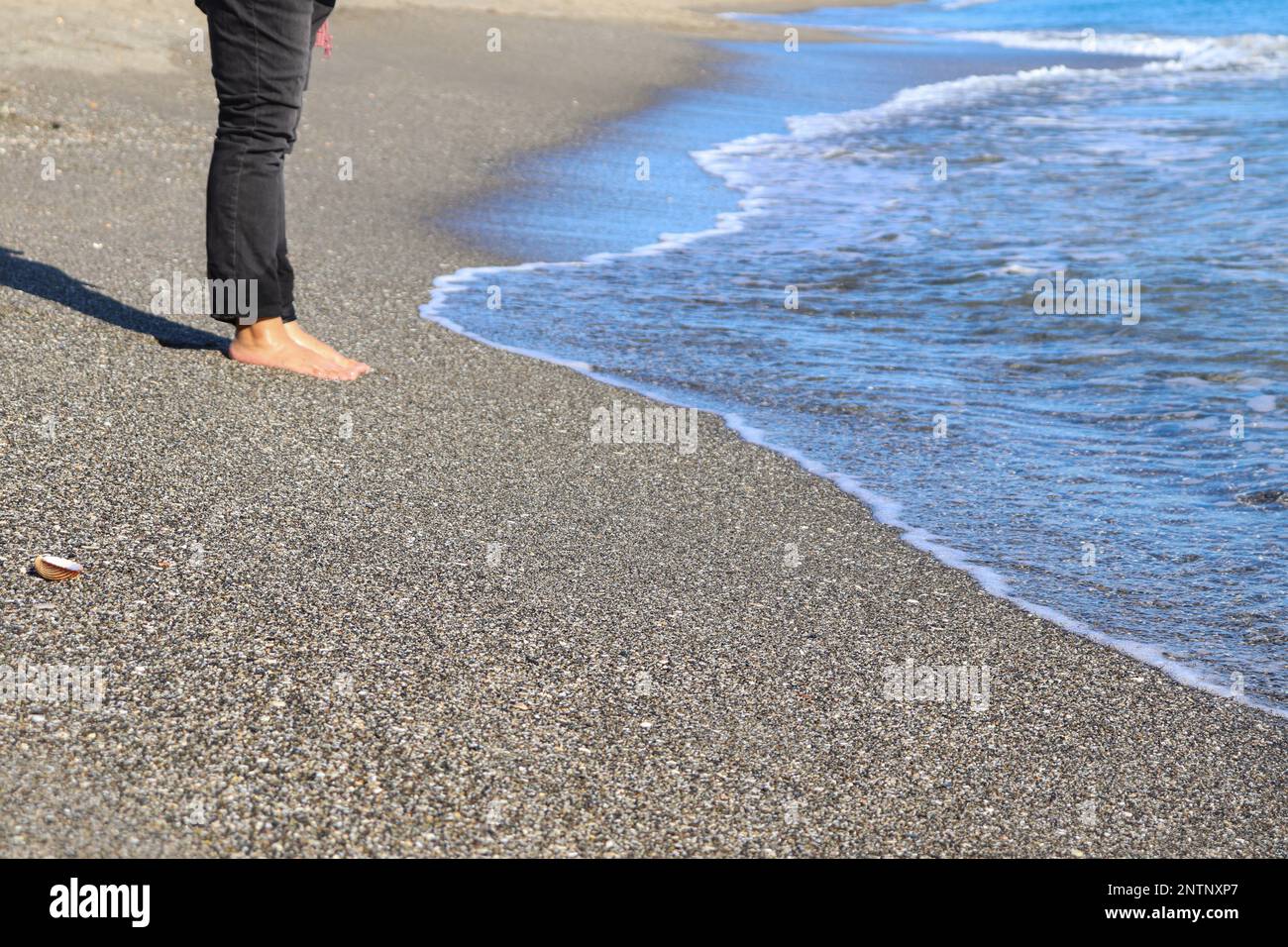 A Woman Standing on the Beach Waiting for The Water to Approach Her ...