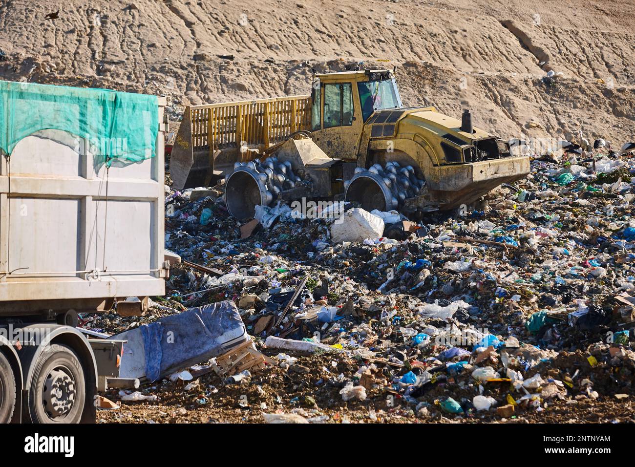 Heavy machinery shredding garbage in an open air landfill. Waste Stock ...