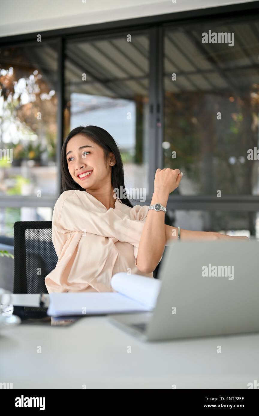 Relaxed millennial Asian businesswoman or female manager stretching her ...