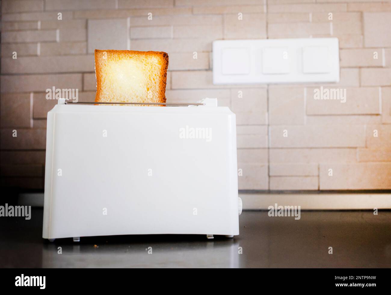 white toaster with ready toasted slice of bread in the kitchen ...