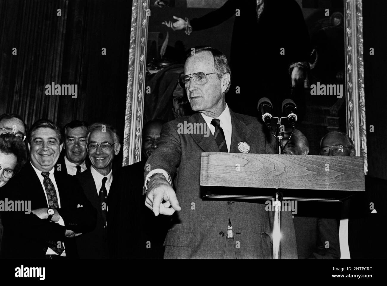 President George H.W. Bush pointing to a tabloid newspaper with Ross ...