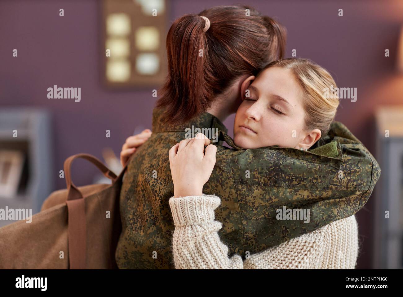 Side view portrait of teen girl embracing mother working in military ...