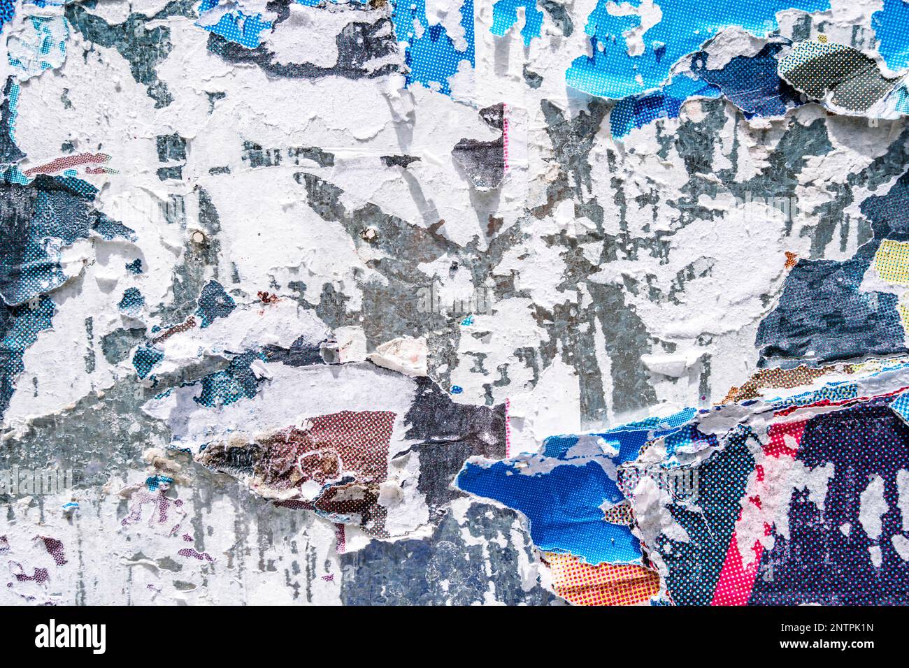 Torn paper collage background on an old poster on a street wall ...