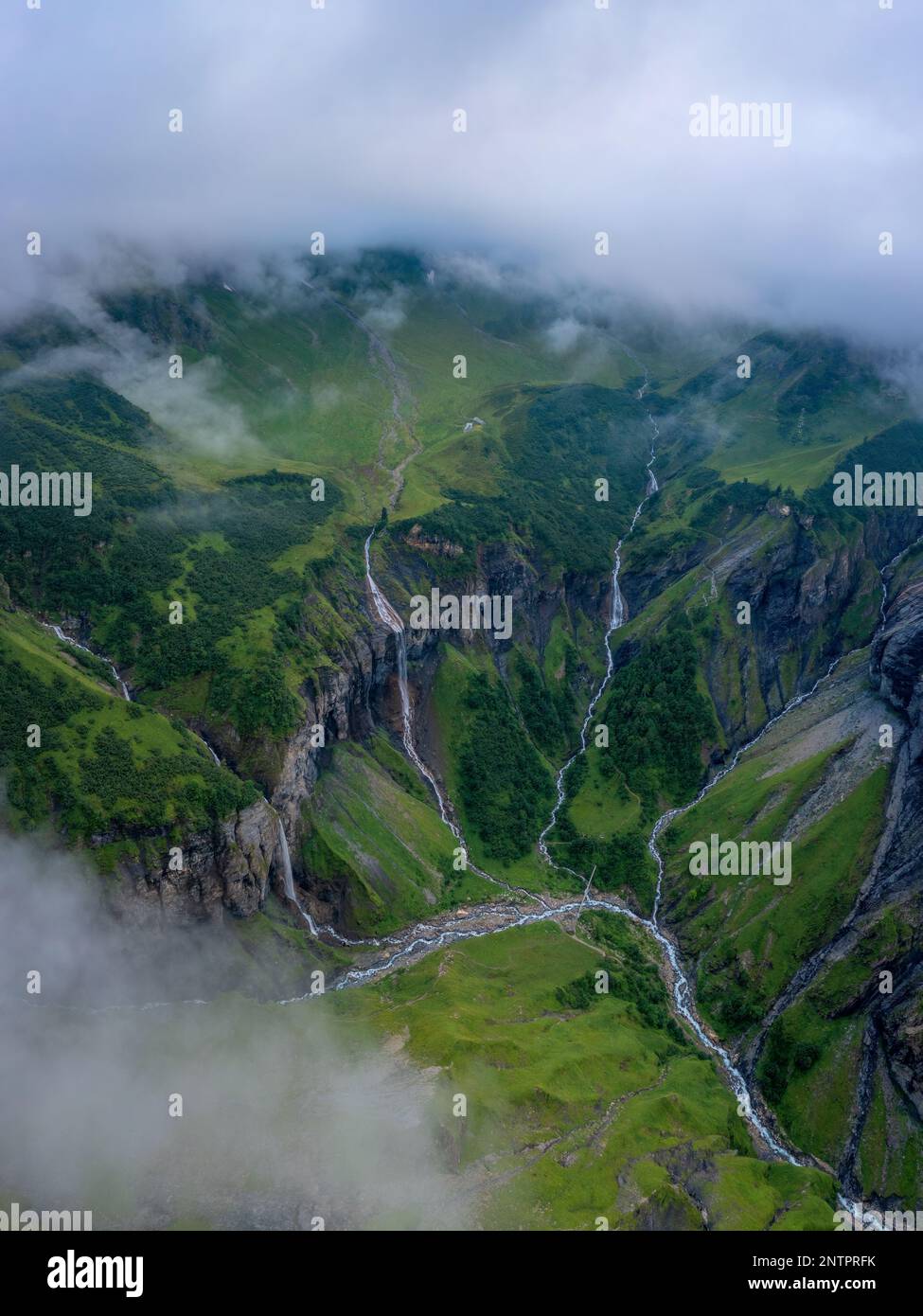 Aerial shot of several large waterfalls cascading down a steep cliff ...