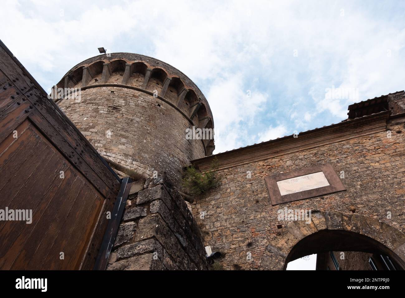 Ancient observation tower of a town in the Tuscan hills with cloudy sky ...