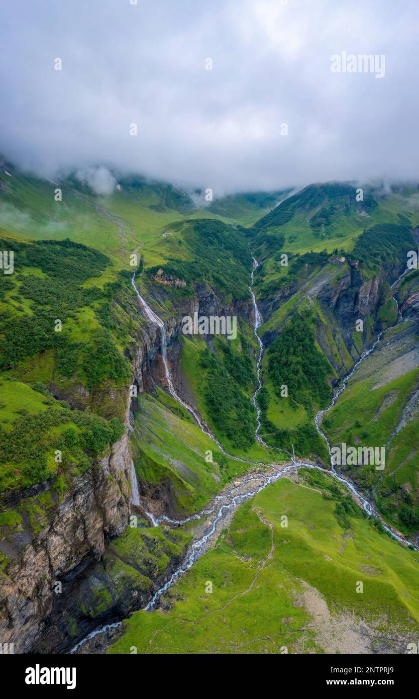 Aerial shot of several large waterfalls cascading down a steep cliff ...