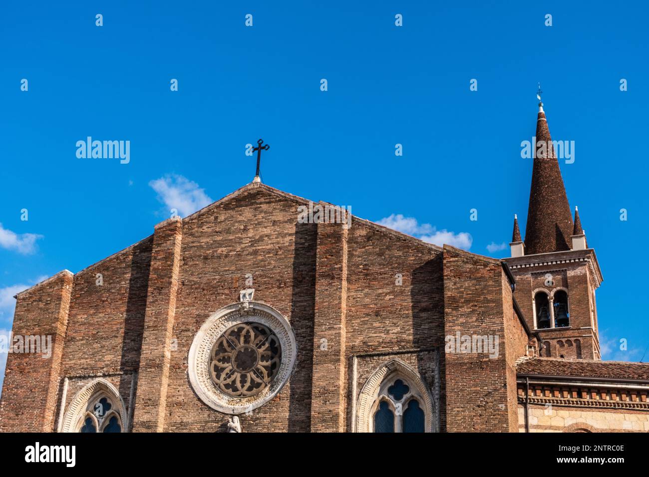 Medieval brick church with pointed roof bell tower on a blue sky day in ...