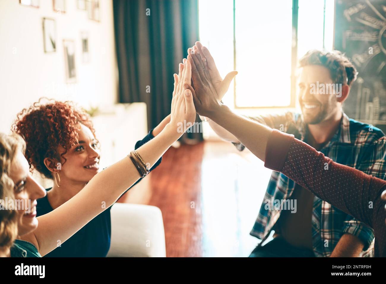 Our team always wins. Shot of a group of designers high fiving together ...