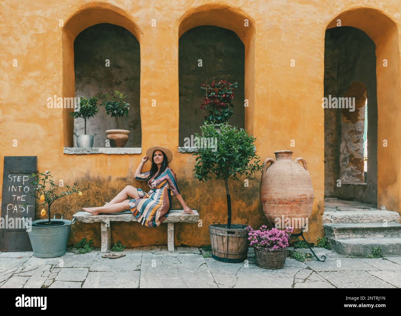Beautiful Happy Girl Wearing Colorful Dress And Sun Hat Sitting On