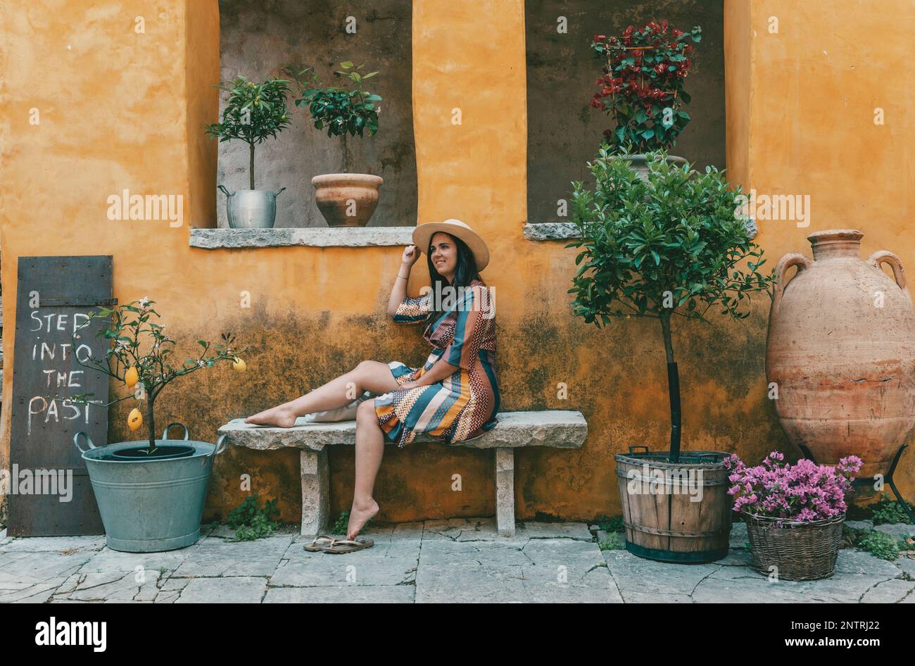 Beautiful Happy Girl Wearing Colorful Dress And Sun Hat Sitting On