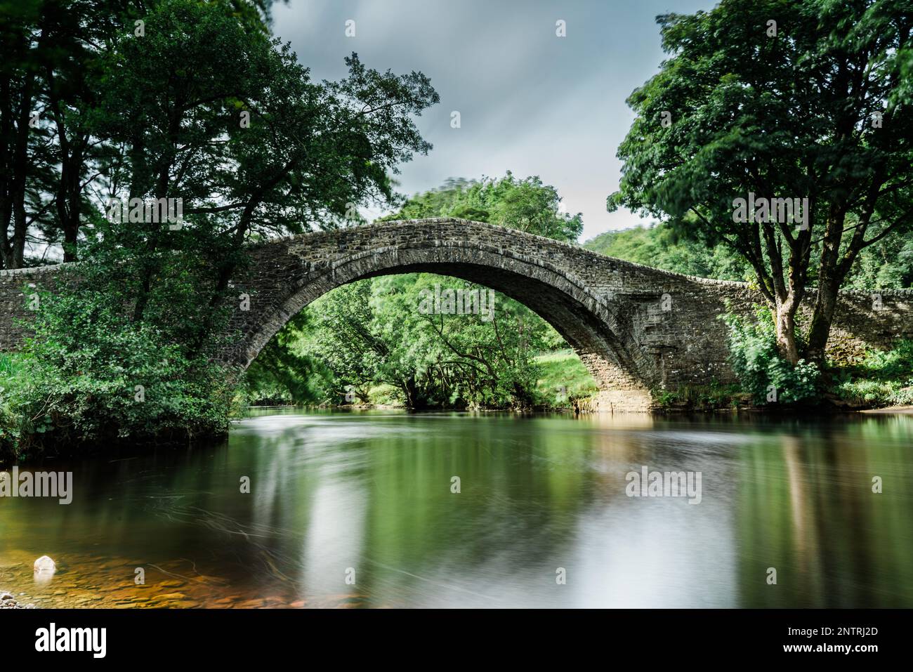 Bridge in the Yorkshire Dales over a river flowing downstream. Long ...