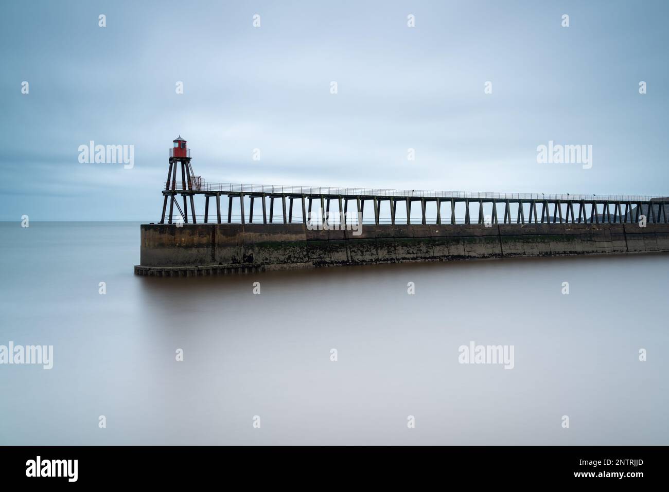 Whitby pier in the harbour and lighthouses to warn the ships and boats ...