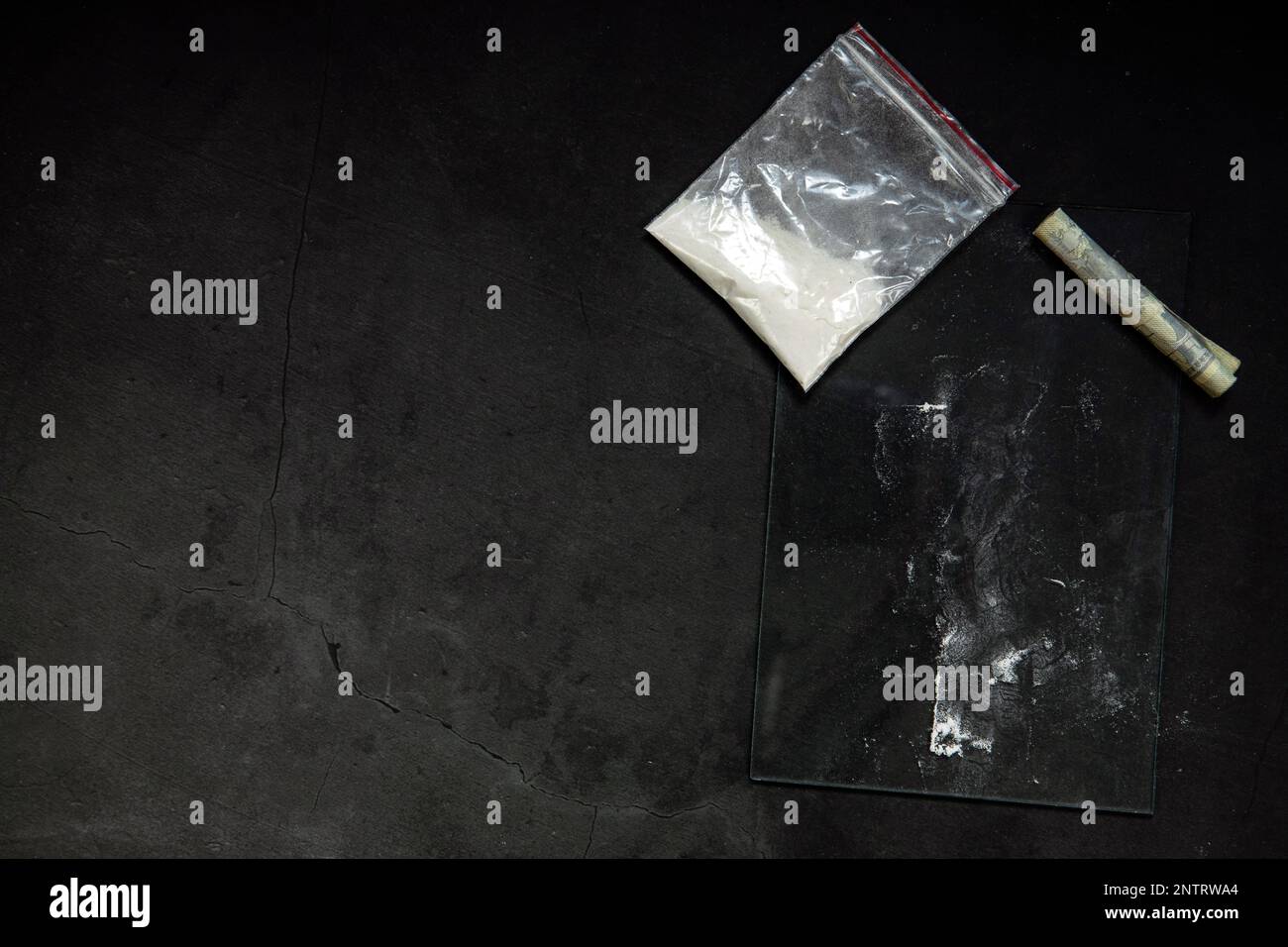 Cocaine powder lines, rolled banknote and drugs in plastic bag pocket ...