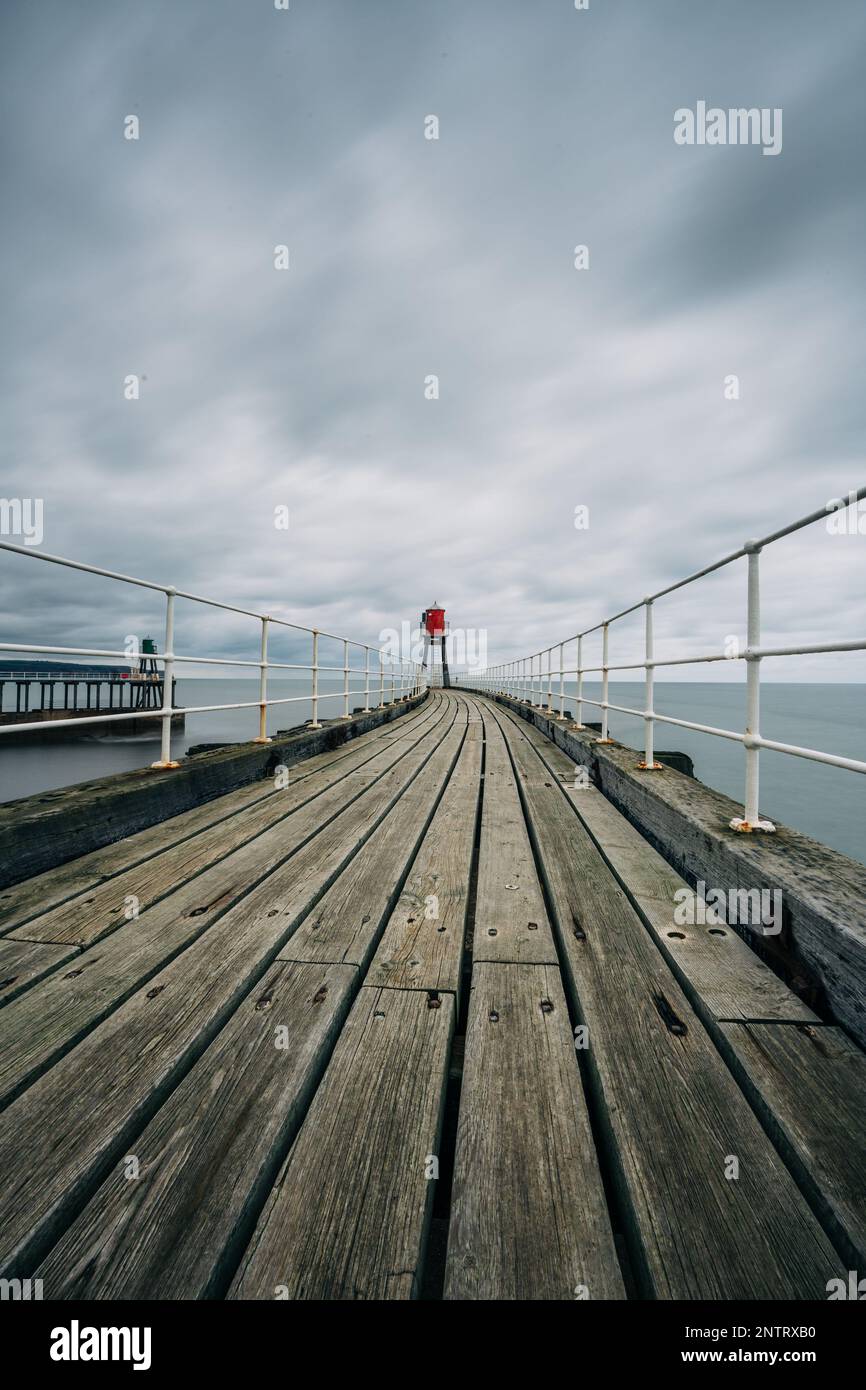 Whitby pier in the harbour and lighthouses to warn the ships and boats ...