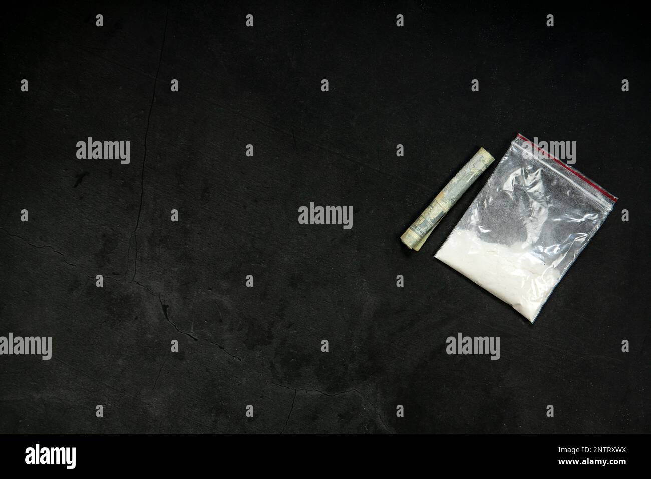 Cocaine powder lines, rolled banknote and drugs in plastic bag pocket ...