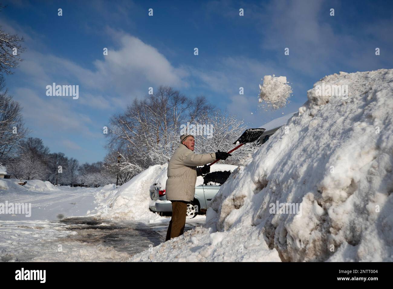 Joe Rohan removes heavy wet snow from his driveway Sunday, March10 ...
