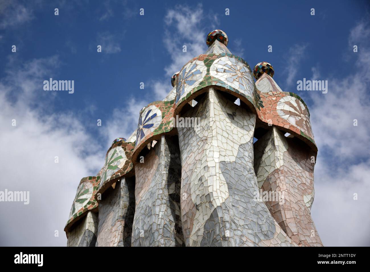 Amazing architecture of chimneys and cross on top of Barcelona ...