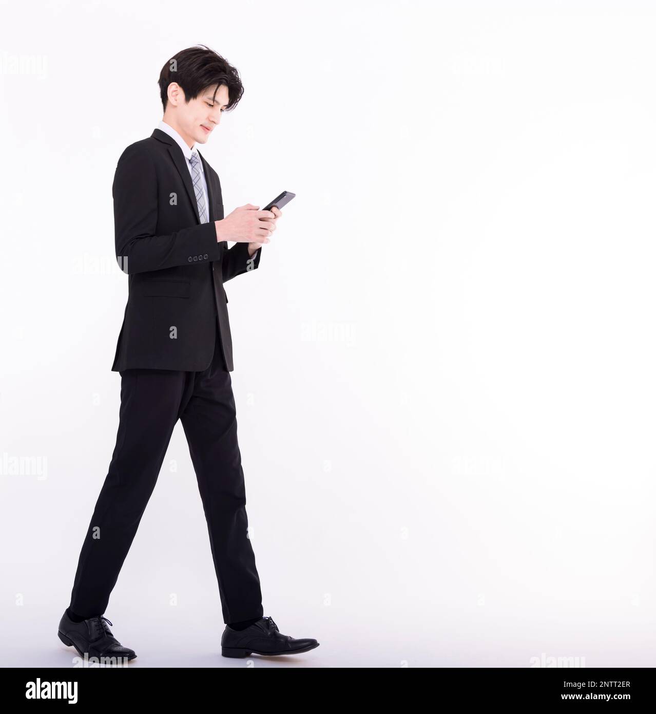 Side view of Business man walking and using mobile phone Stock Photo ...