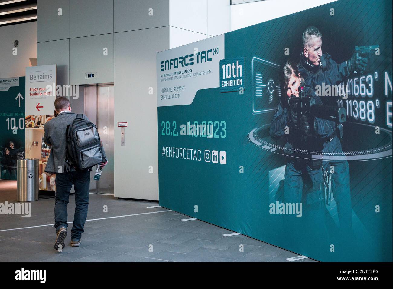 Nuremberg, Germany. 28th Feb, 2023. A trade show visitor walks past an Enforce Tac display. The ...