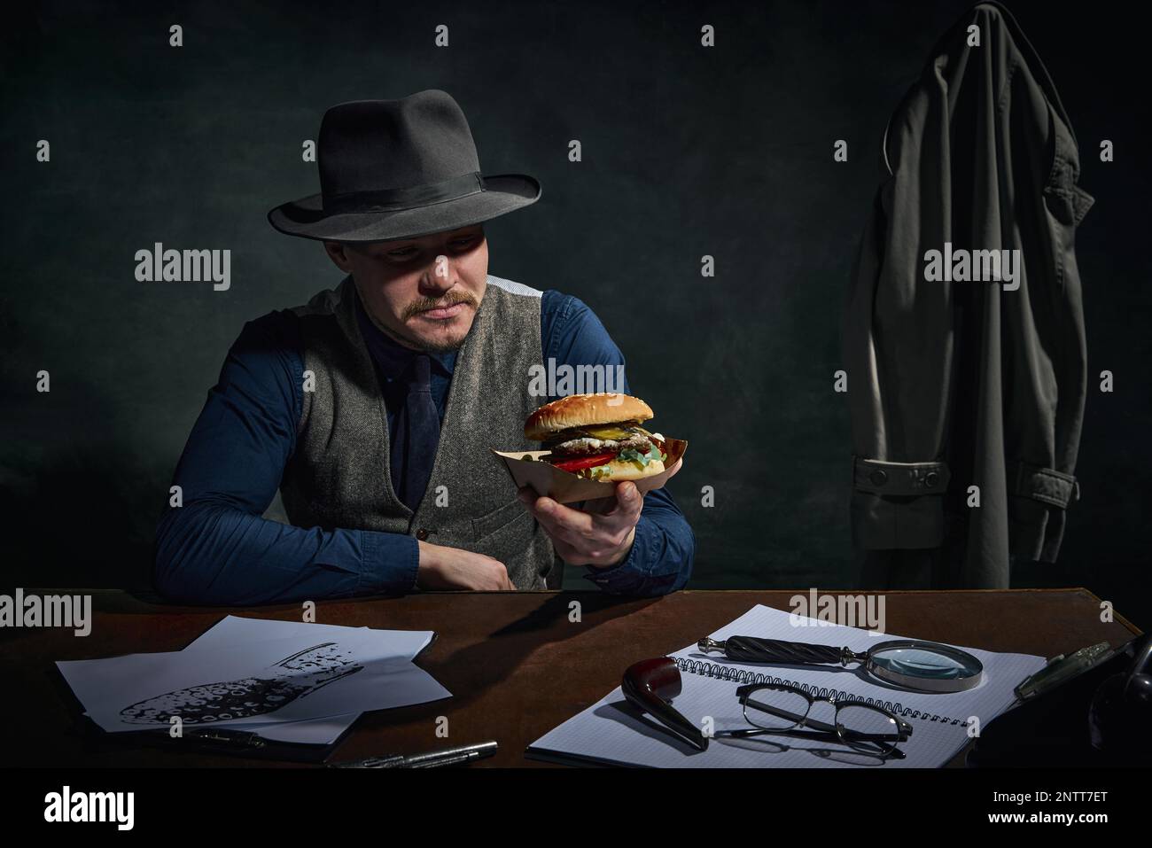 Professional detective in fedora hat sitting at table and having lunch ...