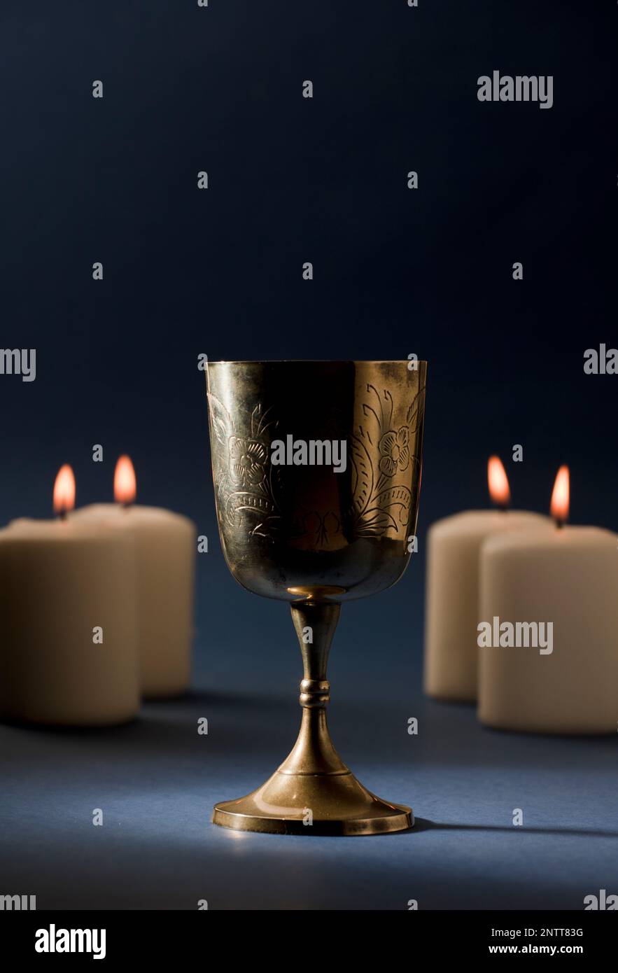 Golden Christian chalice with 4 candles with flames, blue altar, brown ...