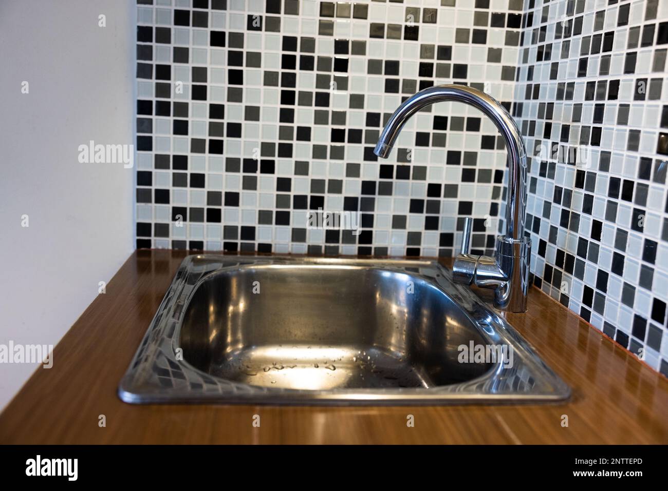 Clean sink with pouring water in the kitchen, metal faucet and sink in ...