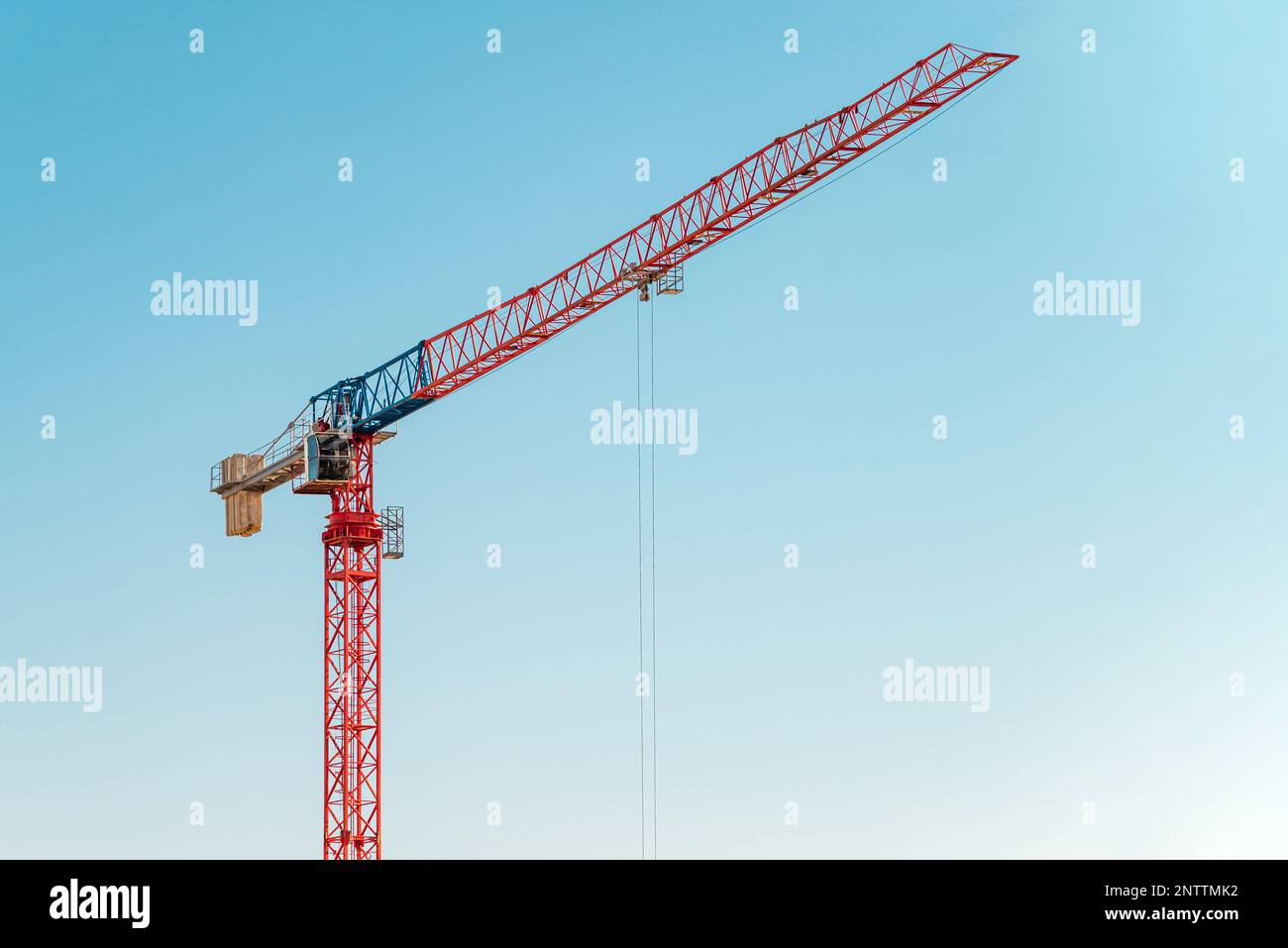 Construction crane in front of cloudless sunny blue sky Stock Photo - Alamy