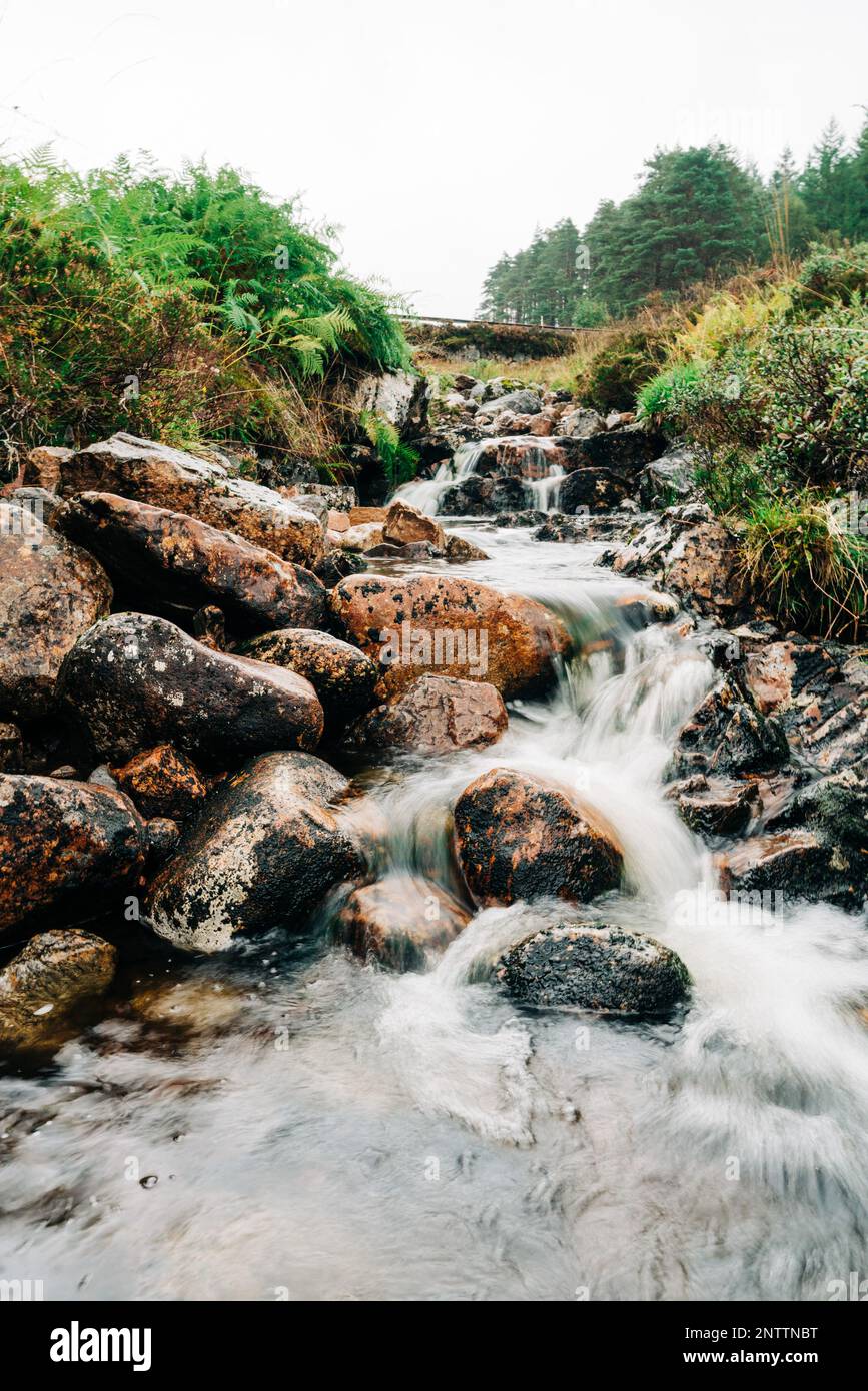 Waterfall in Glencoe in the Scottish Highlands with mountains imposing ...