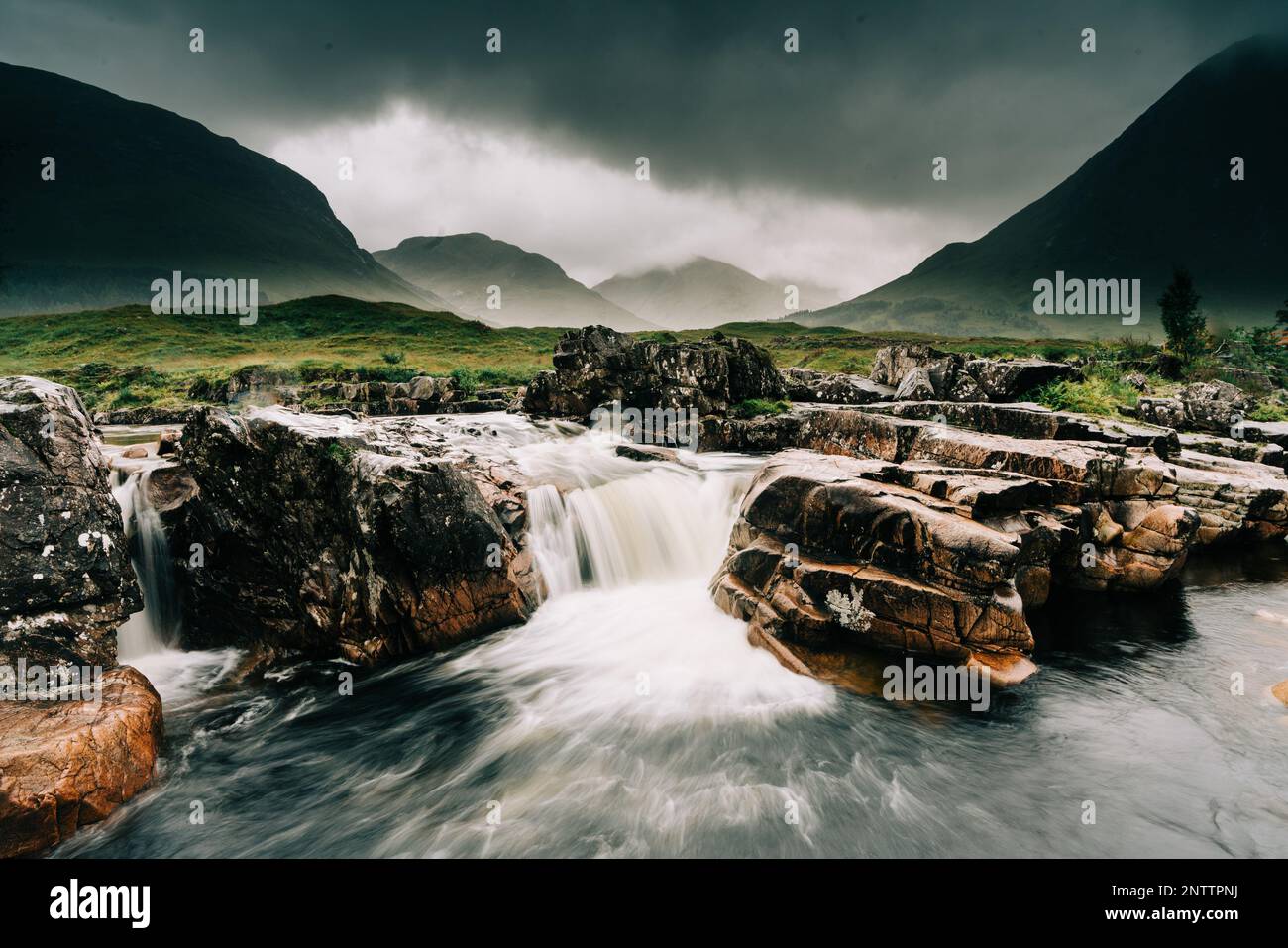 Waterfall in Glencoe in the Scottish Highlands with mountains imposing ...