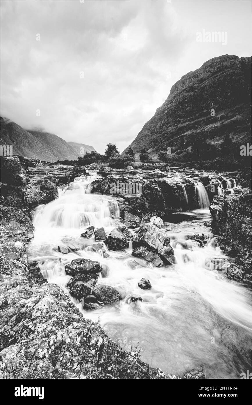 Waterfall in Glencoe in the Scottish Highlands with mountains imposing ...