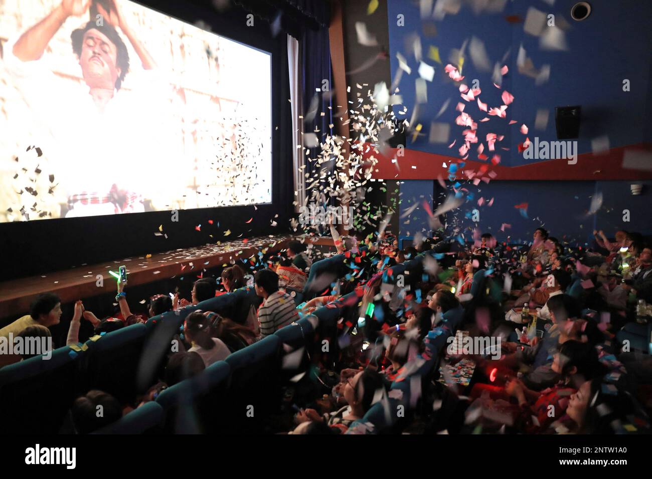 Audience shout and throw bits of paper during the "Masala movie showing ...